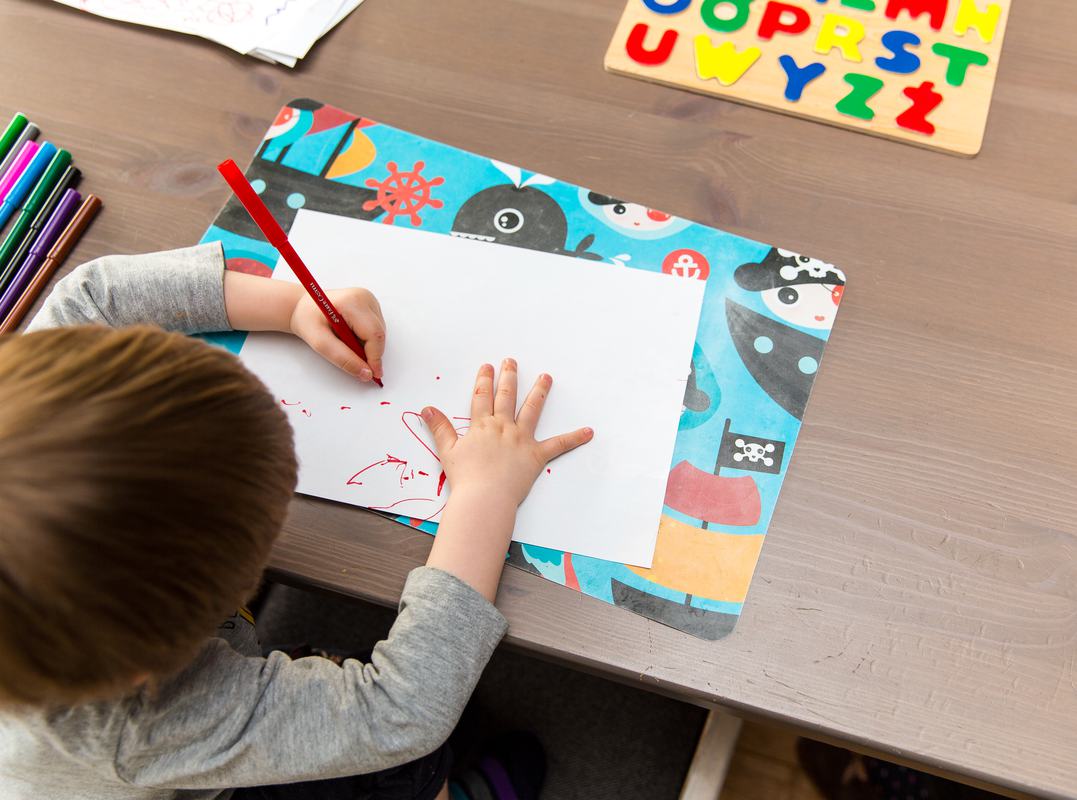 Free Photo: Left-Handed Little Boy Drawing with Red Marker